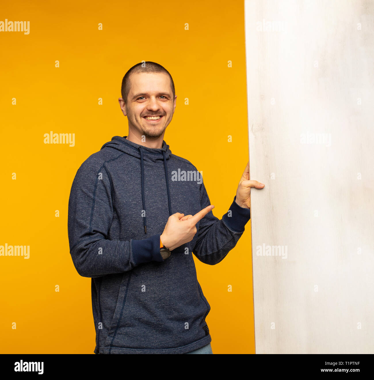 Man holding big white wooden banner and pointing on it Stock Photo - Alamy