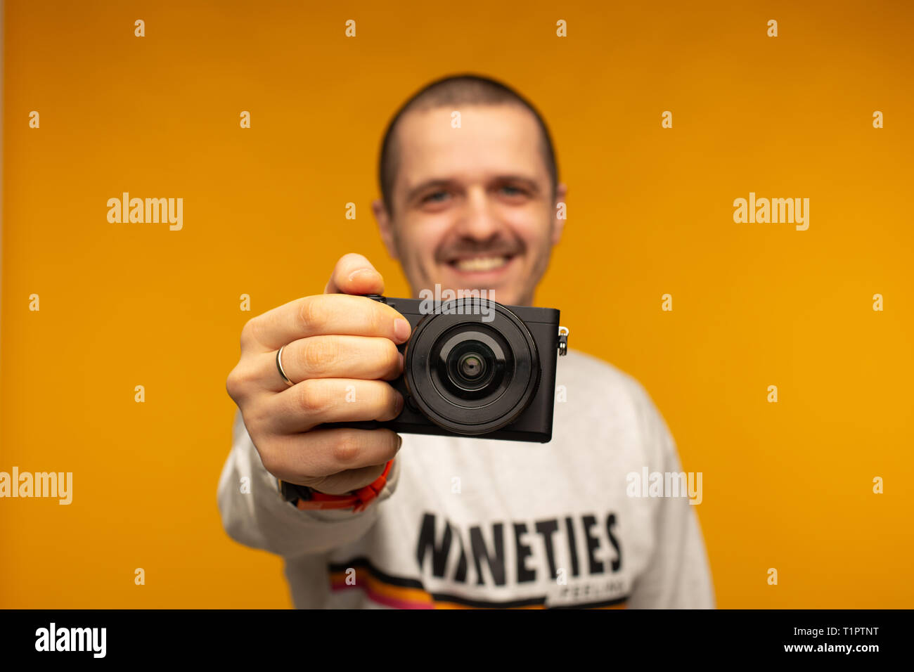 Photographer man holding mirorrless camera in his hand Stock Photo - Alamy