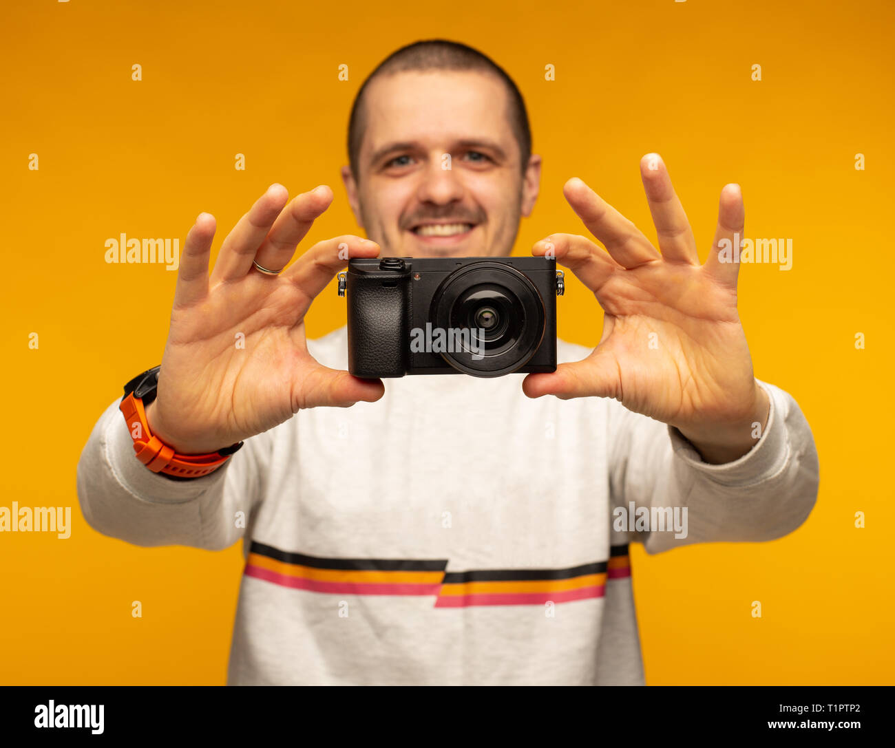 Man photographer holding mirrorless camera in both hands Stock Photo ...