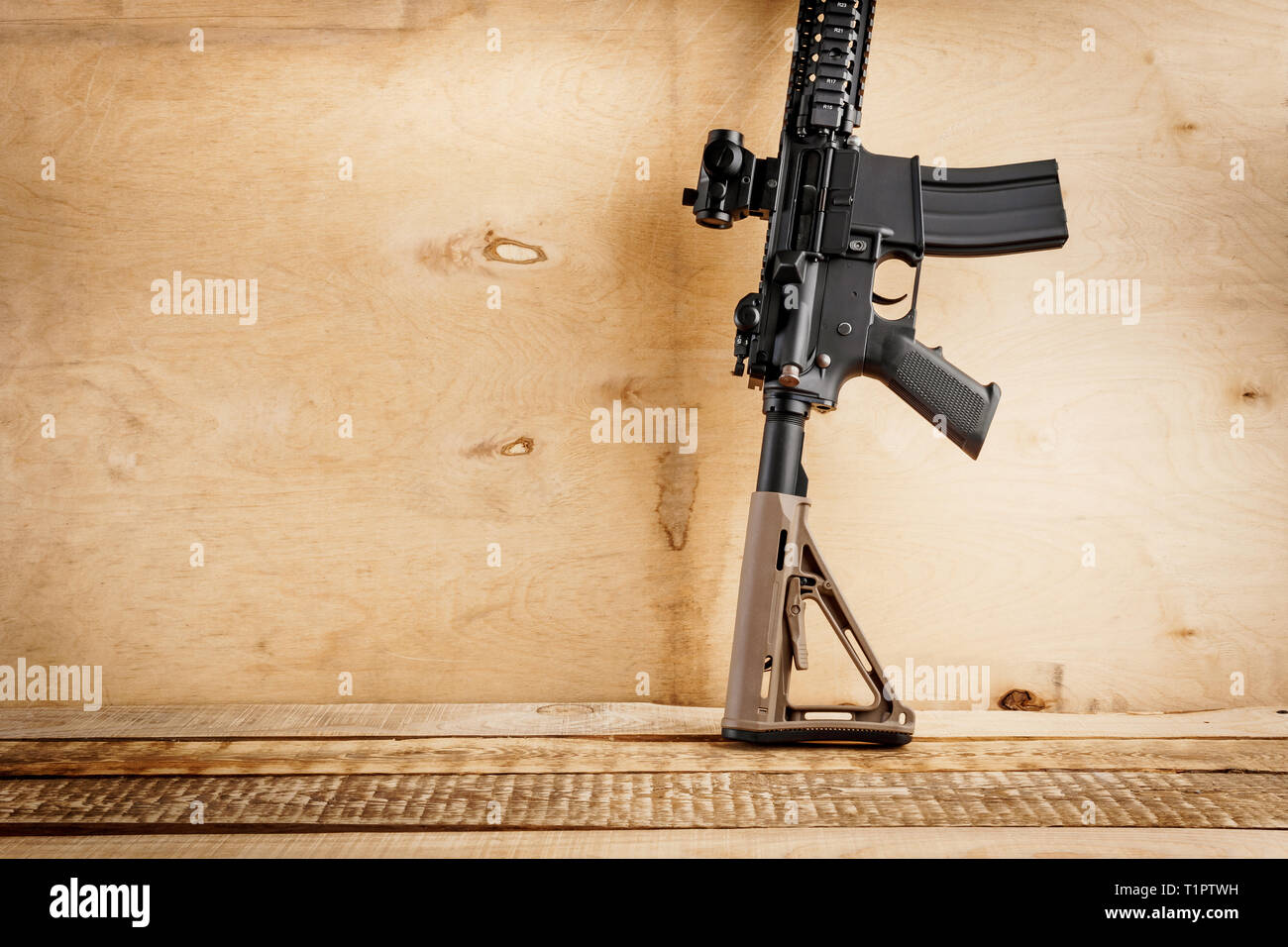 black assault rifle on an old wooden table Stock Photo - Alamy