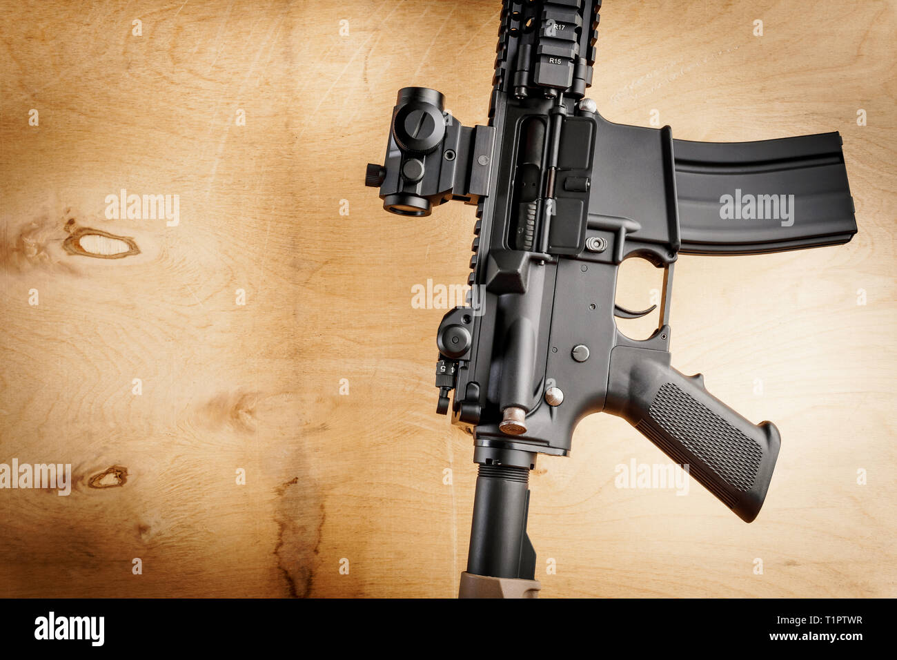 black assault rifle on an old wooden table Stock Photo - Alamy
