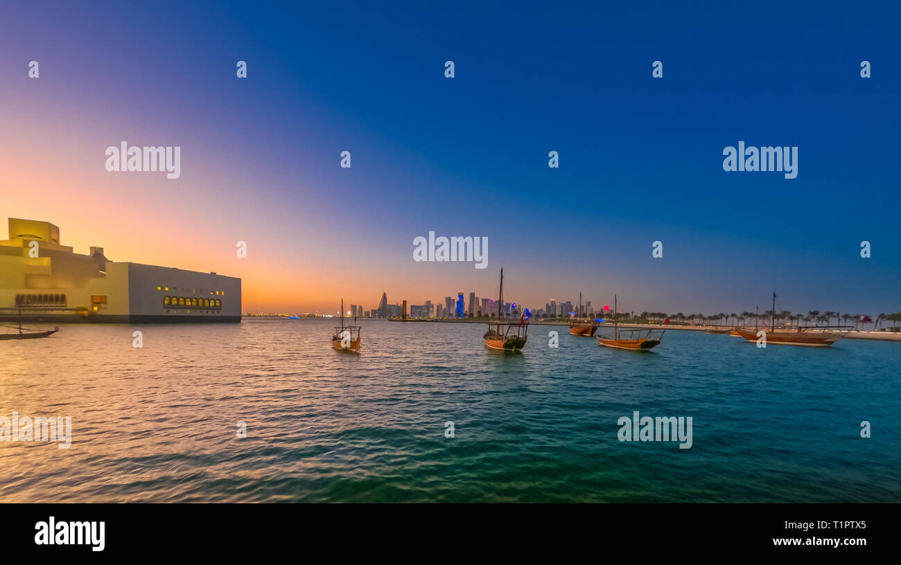 Scenary seafront landscape of Doha Bay at twilight. Traditional dhows ...