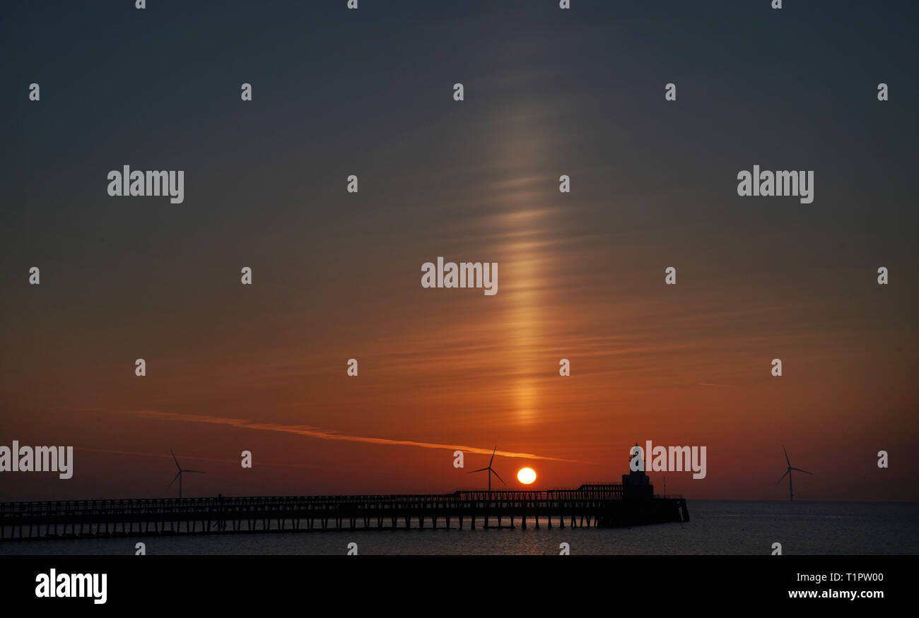 A rare light pillar above Blyth lighthouse on the coast of ...
