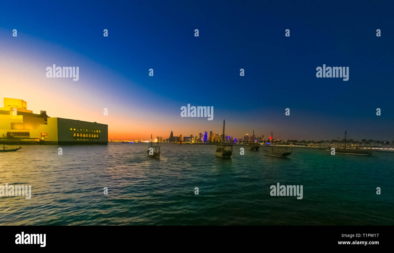 Scenary seafront landscape of Doha Bay after sunset. Traditional dhows ...