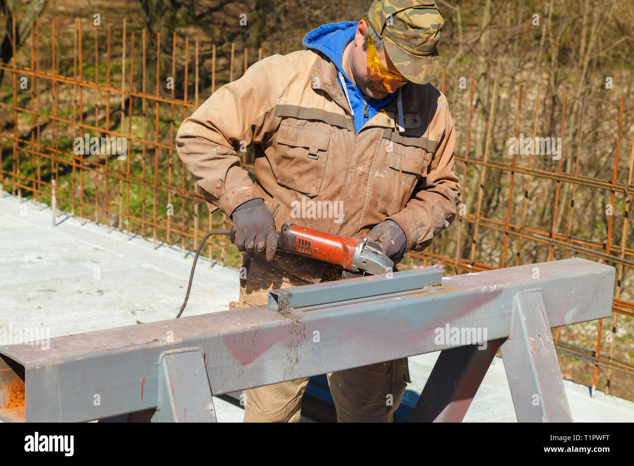 An employee in white overalls and a protective mask processes with ...