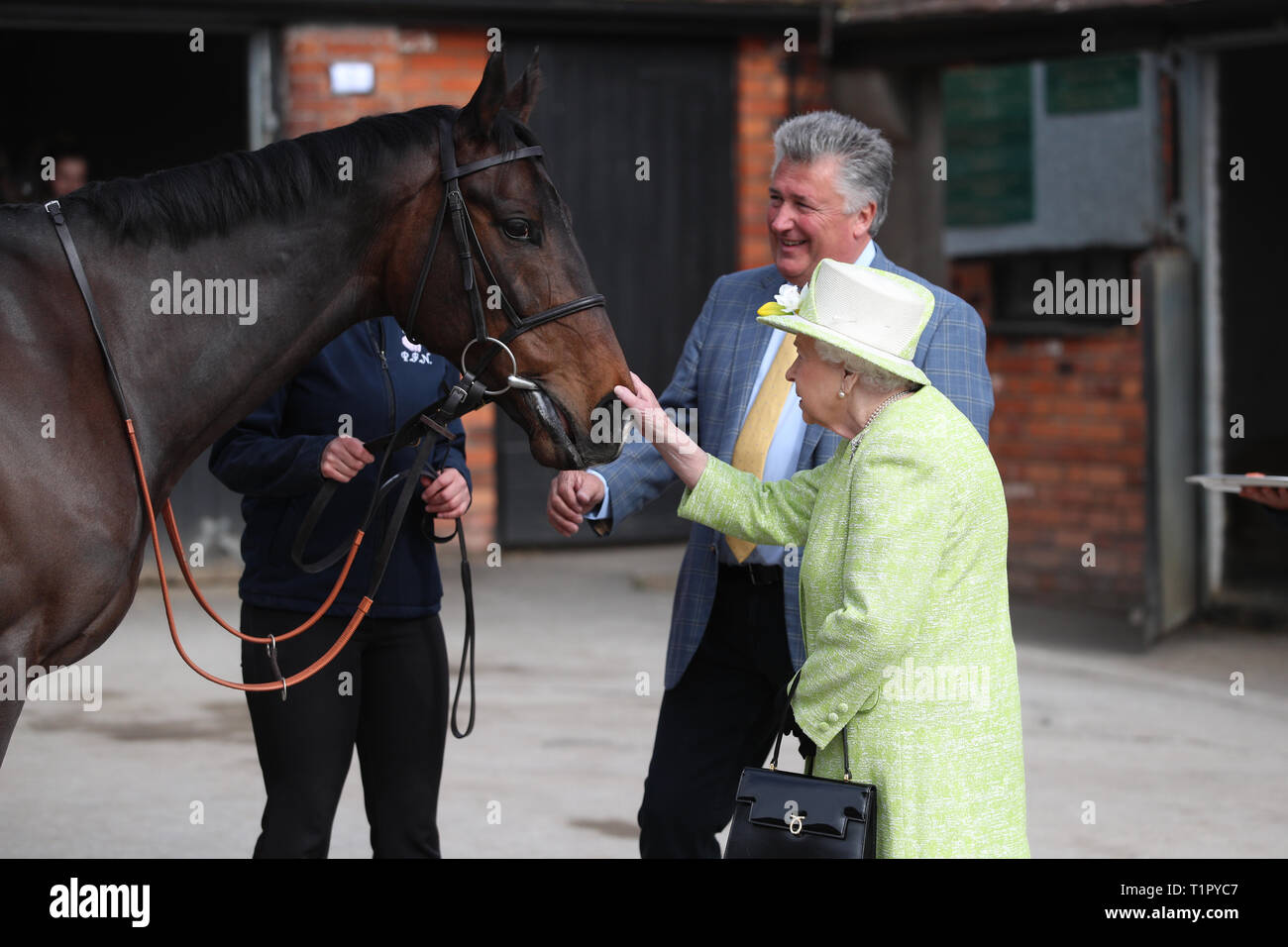 Queen Elizabeth II with trainer Paul Nicholls feeding carrots to a ...