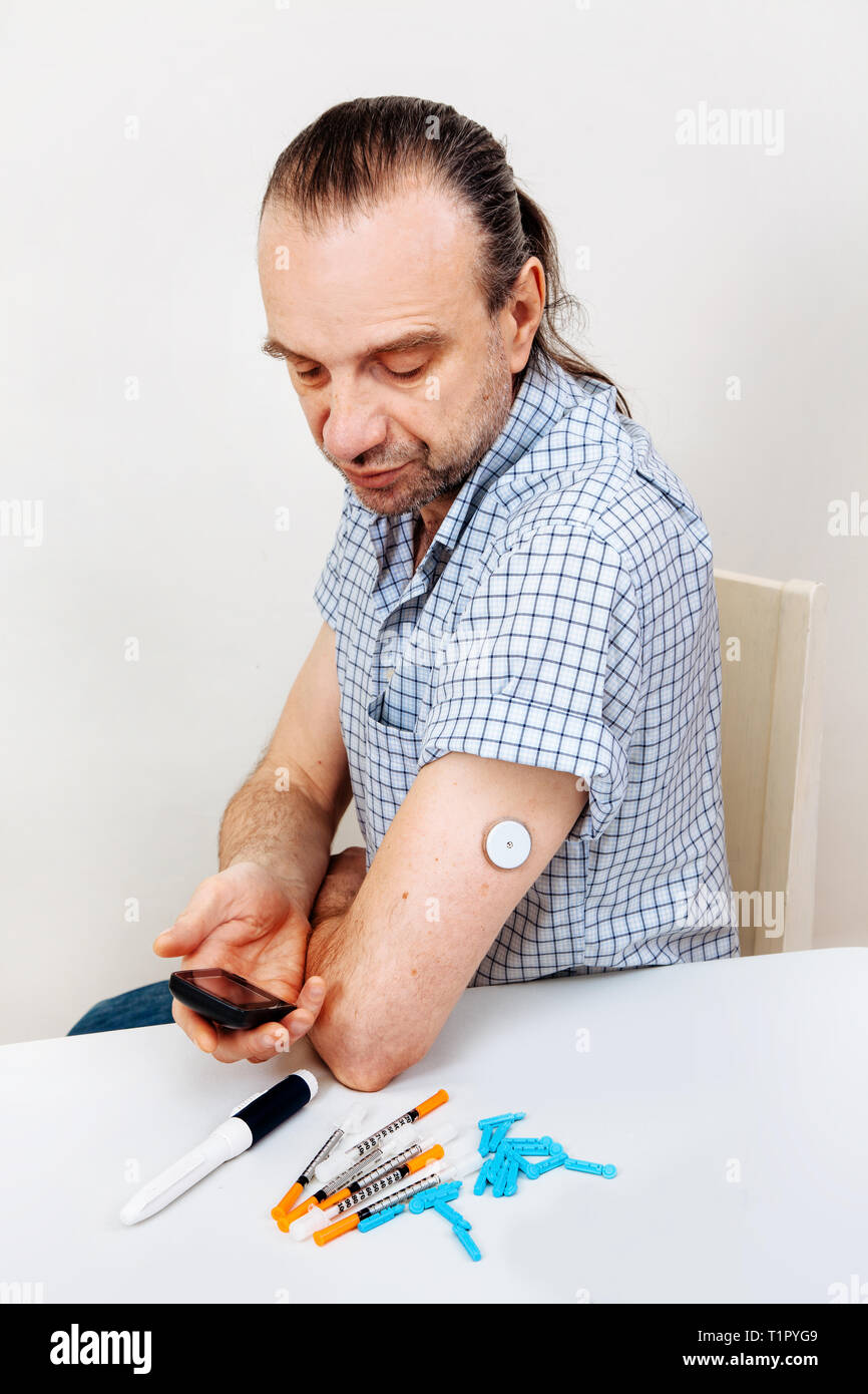 Man testing glucose level with a digital glucometer, sensor checkup ...