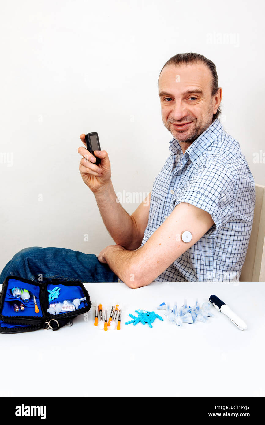 Man testing glucose level with a digital glucometer, sensor checkup ...