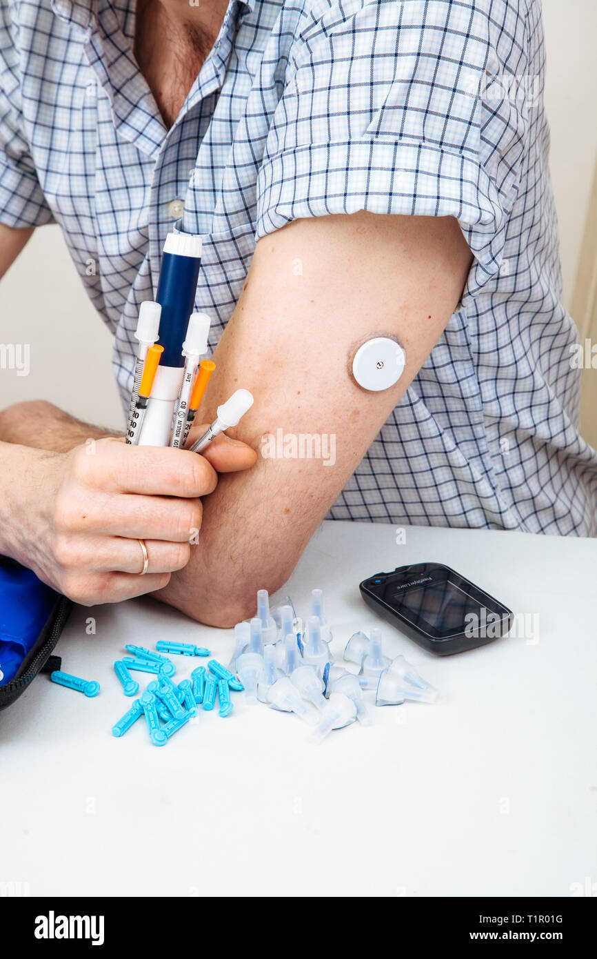 Man testing glucose level with a digital glucometer, sensor checkup ...