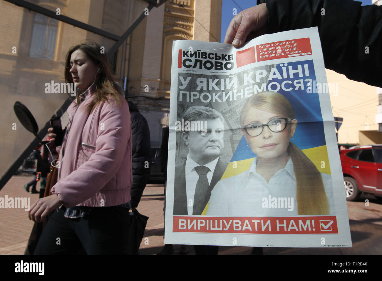 March 28, 2019 - Kiev, Ukraine - A woman passes by a supporter who ...