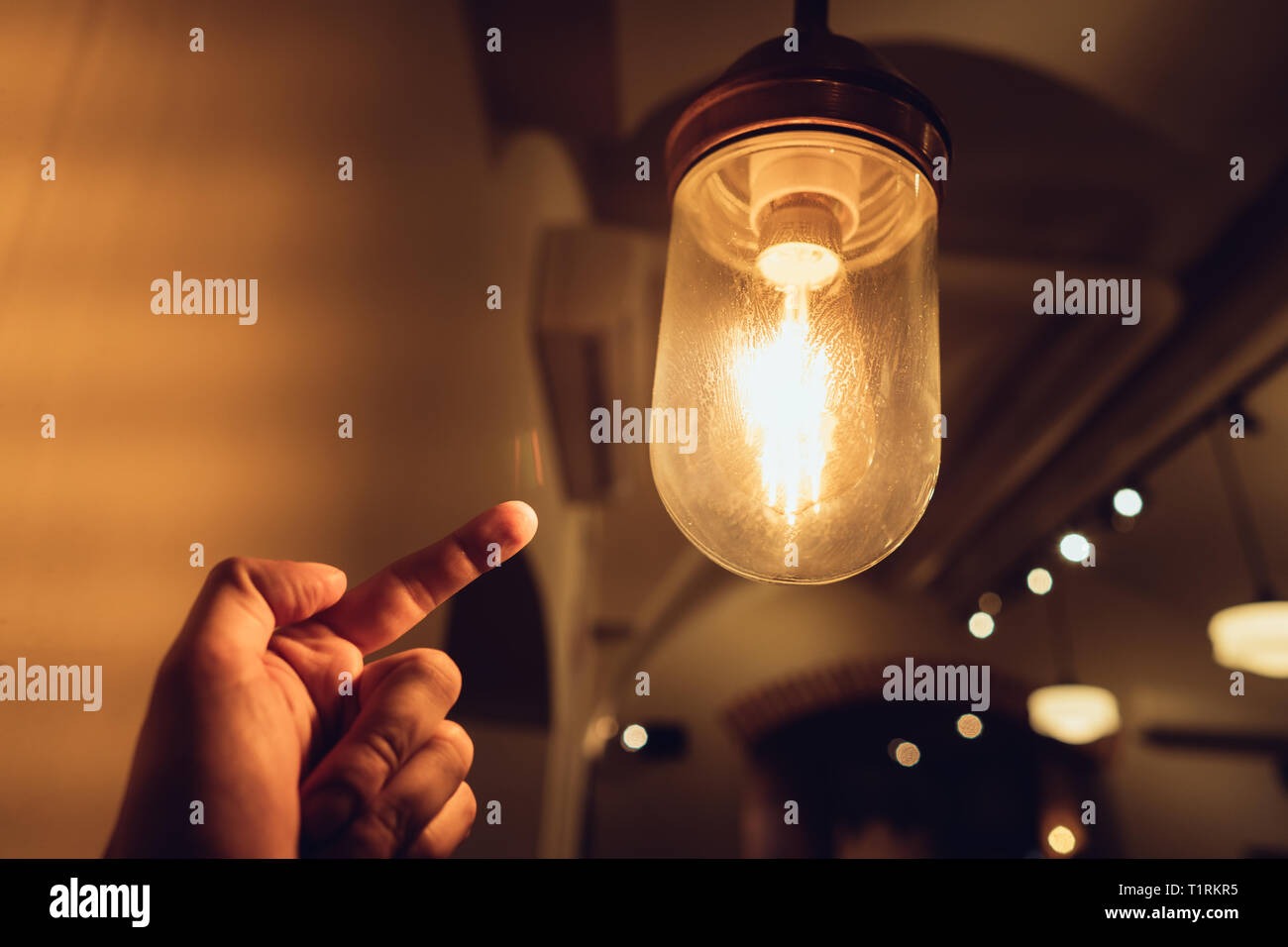 Hand reaching for a vintage light bulb Stock Photo - Alamy