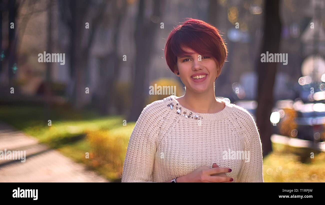 Portrait of young cool caucasian pink-haired girl watching smilingly ...