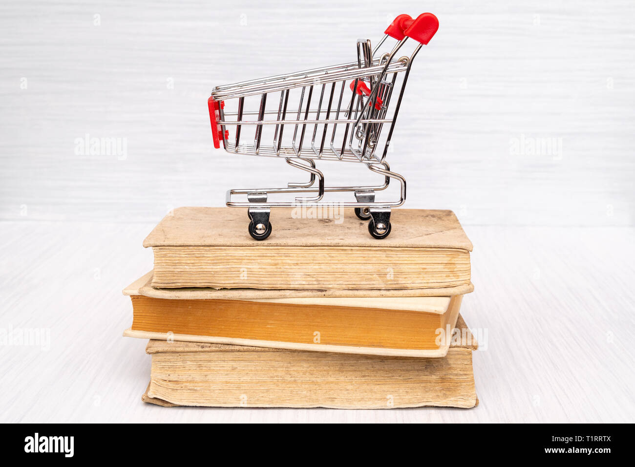 Shopping cart on the books. Buying or selling books concept Stock Photo ...