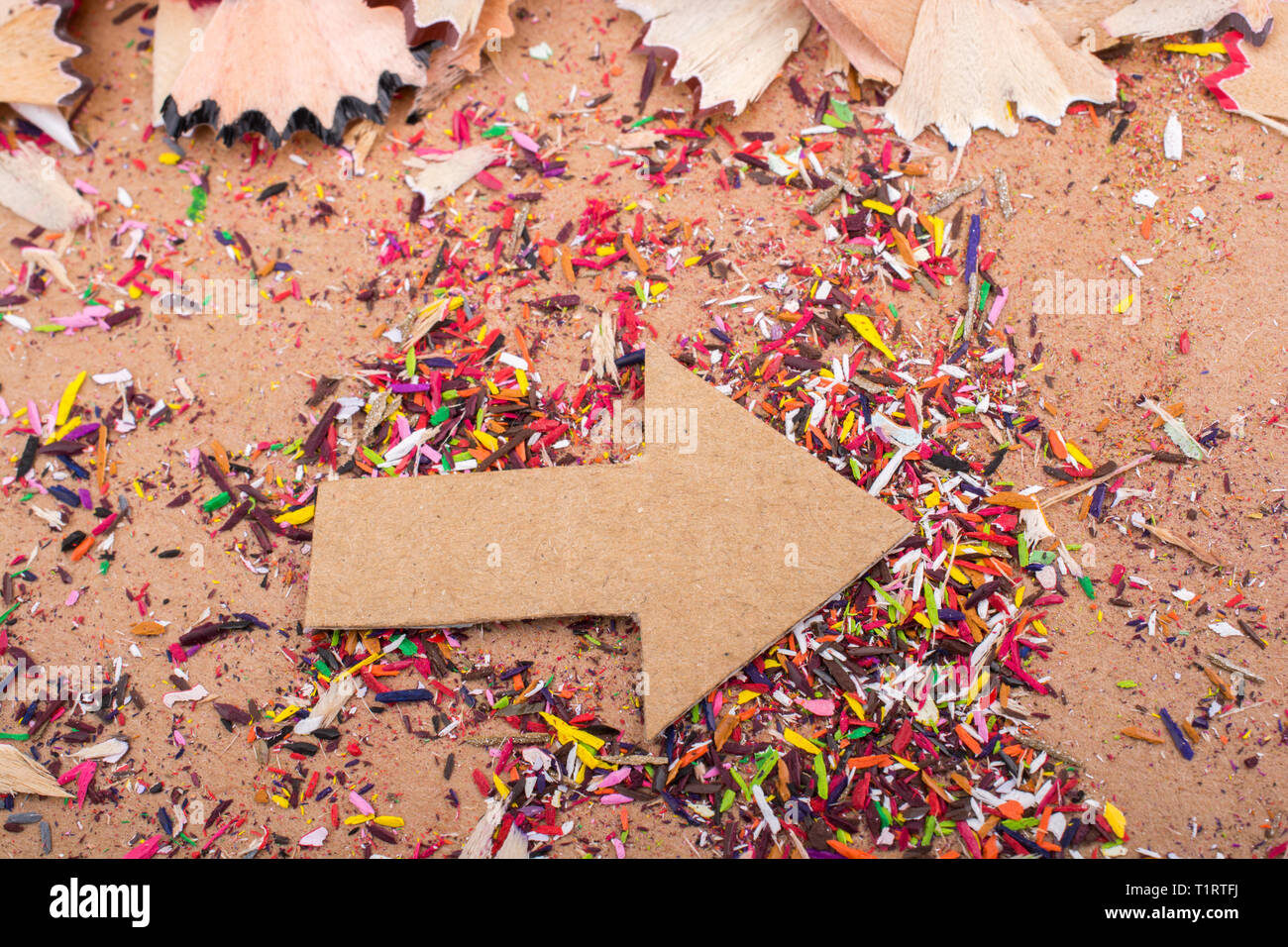 Arrow cut out of paper amid pencil shavings on canvas Stock Photo - Alamy