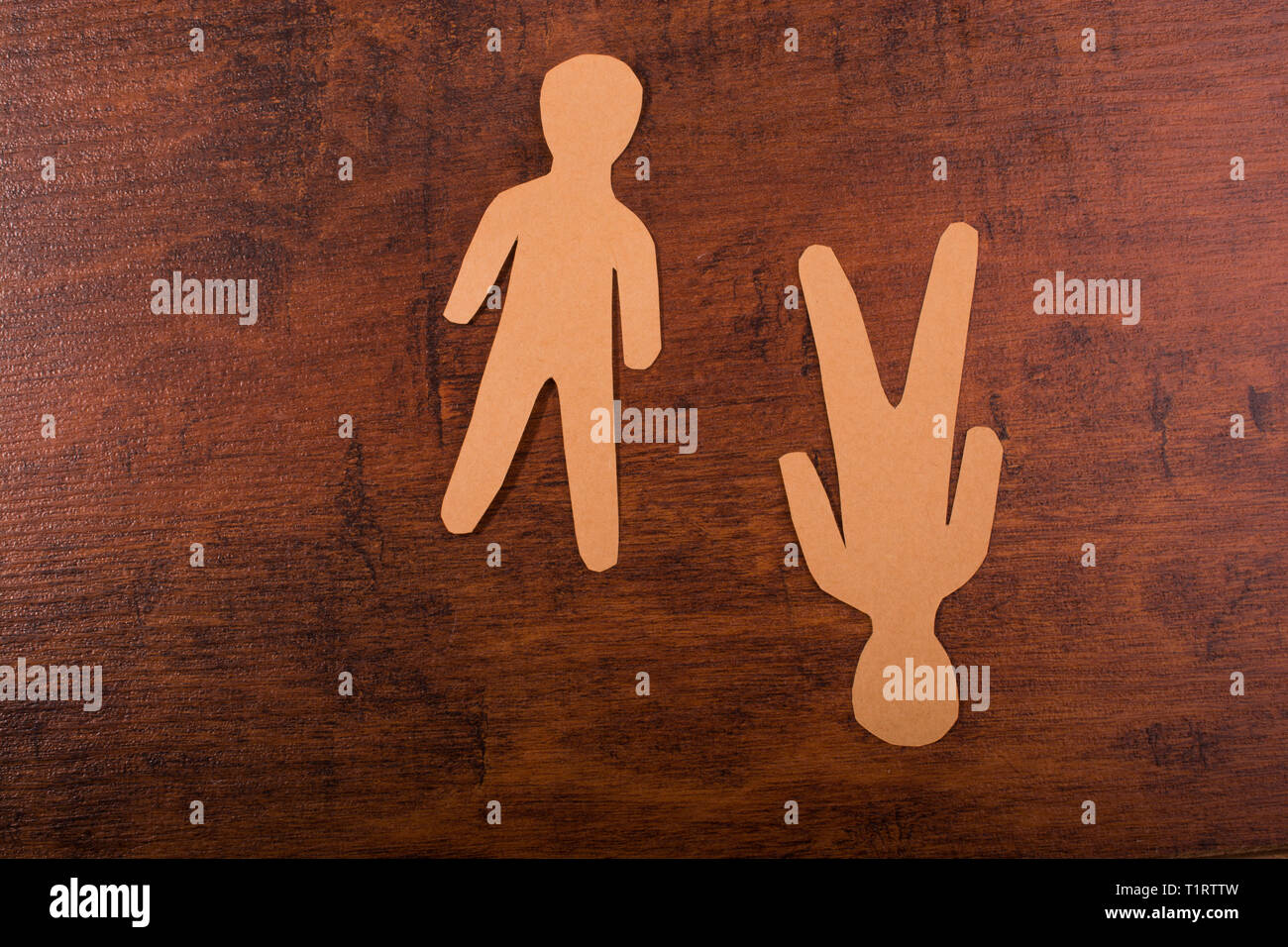 Man shape cut out of paper on wooden texture Stock Photo - Alamy