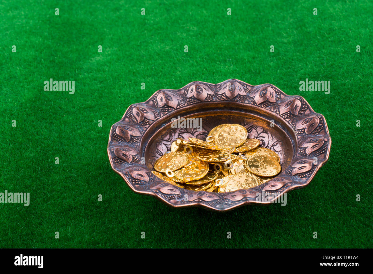 Fake gold coins in an old decorative metal plate Stock Photo - Alamy