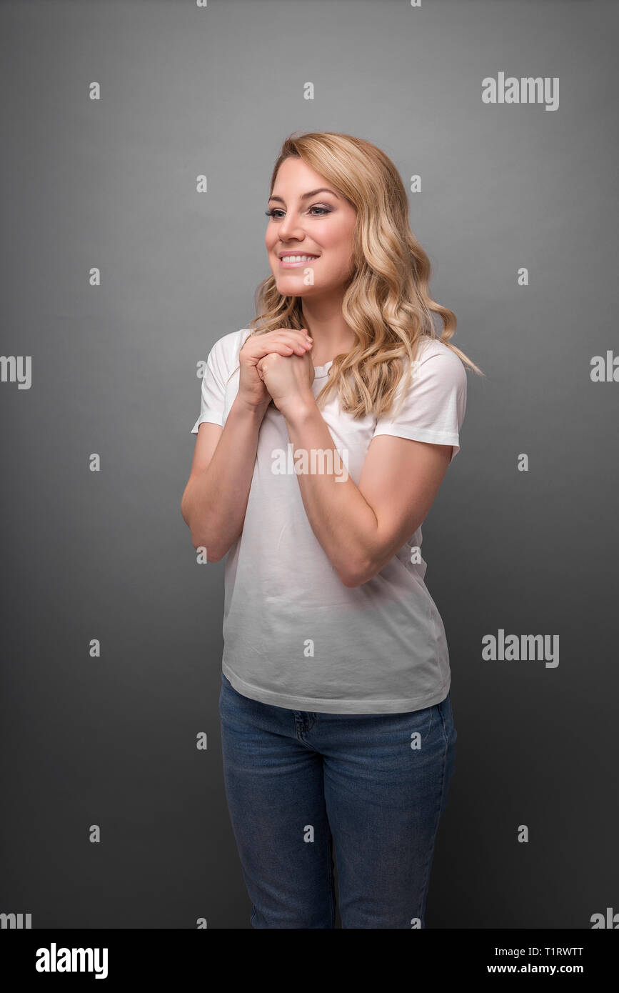 The woman folded her arms over her chest like during a prayer on gray ...