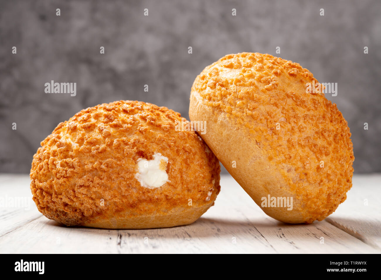 two pieces sweet puffs on a white wood table Stock Photo - Alamy