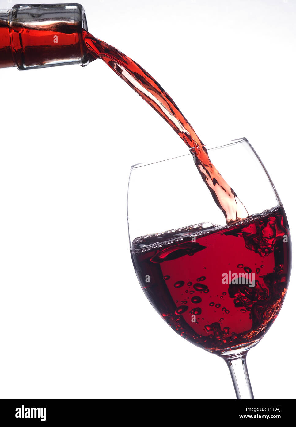 Pouring a glass of red wine on a bright background Stock Photo - Alamy