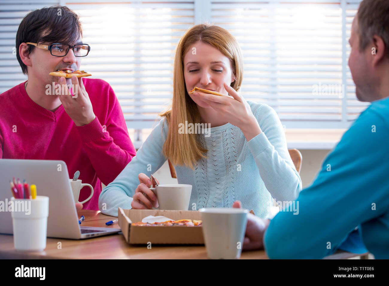 Happy business People Having Meeting And Eating Pizza in office. Three ...