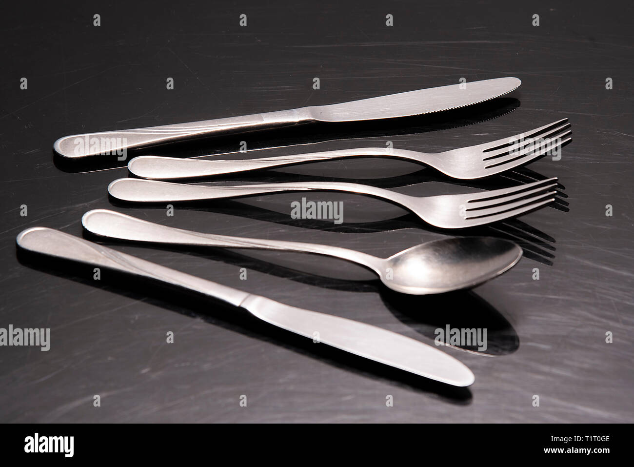 Two silver knives, two forks and a spoon are on the table Stock Photo ...