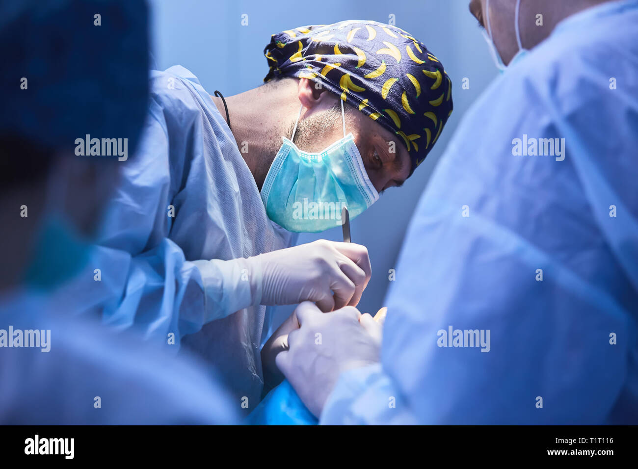 Serious surgeons during a surgery in the hospital. Cross Process Stock ...