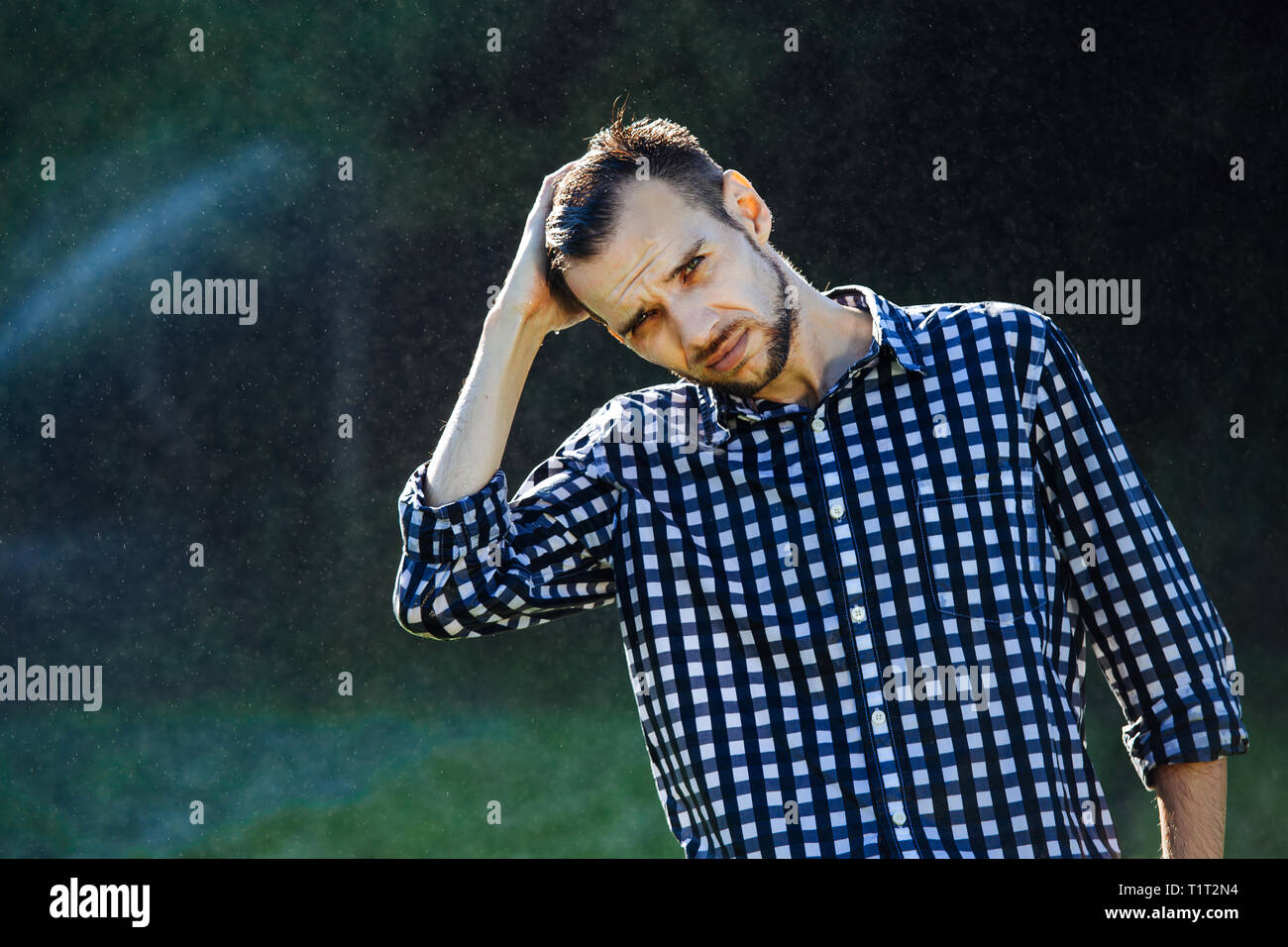 Portrait of a strong, drenched man in the rain. Young man getting wet ...
