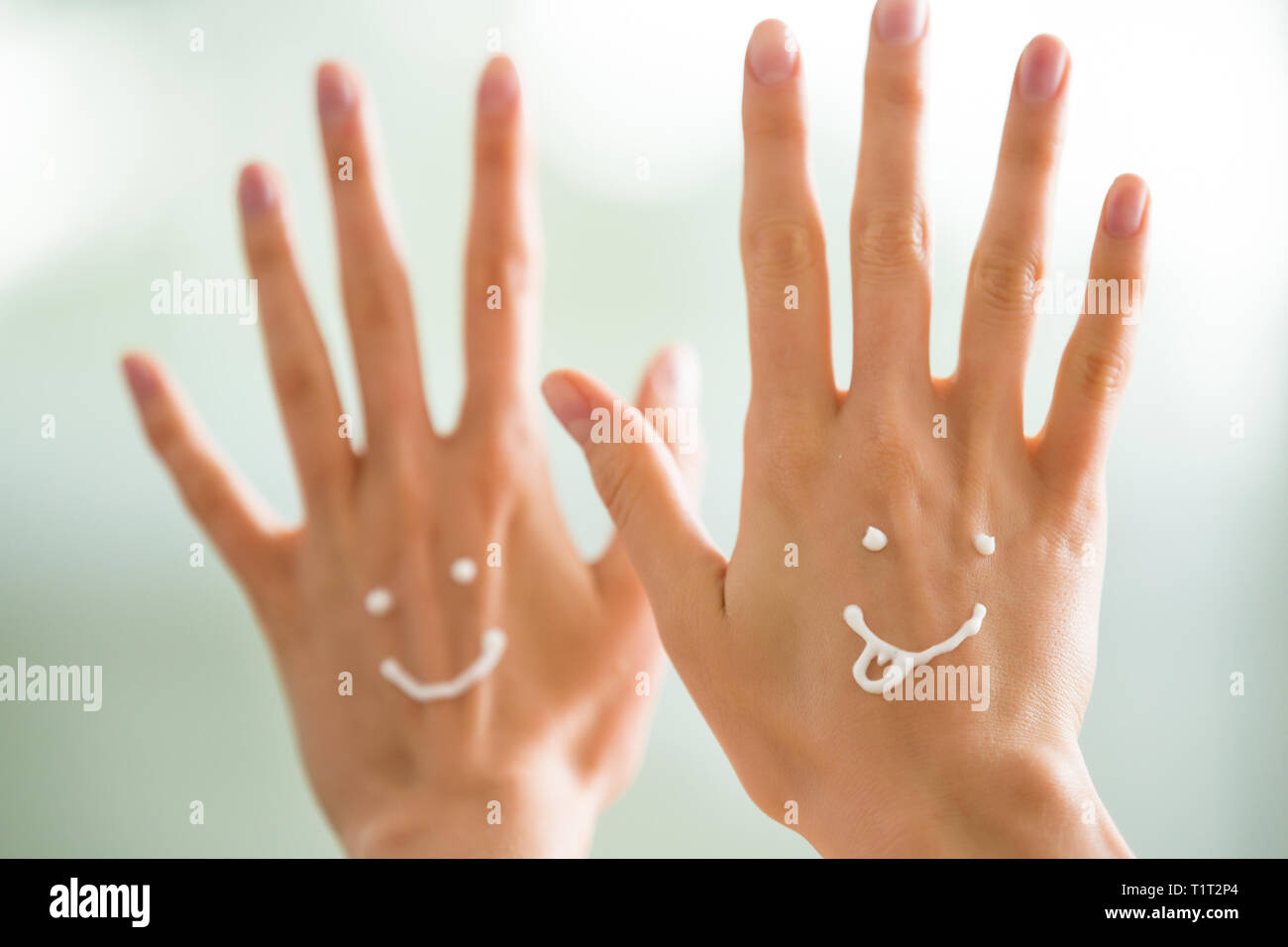Closeup woman beautiful hands with long fingers applying moisturising ...