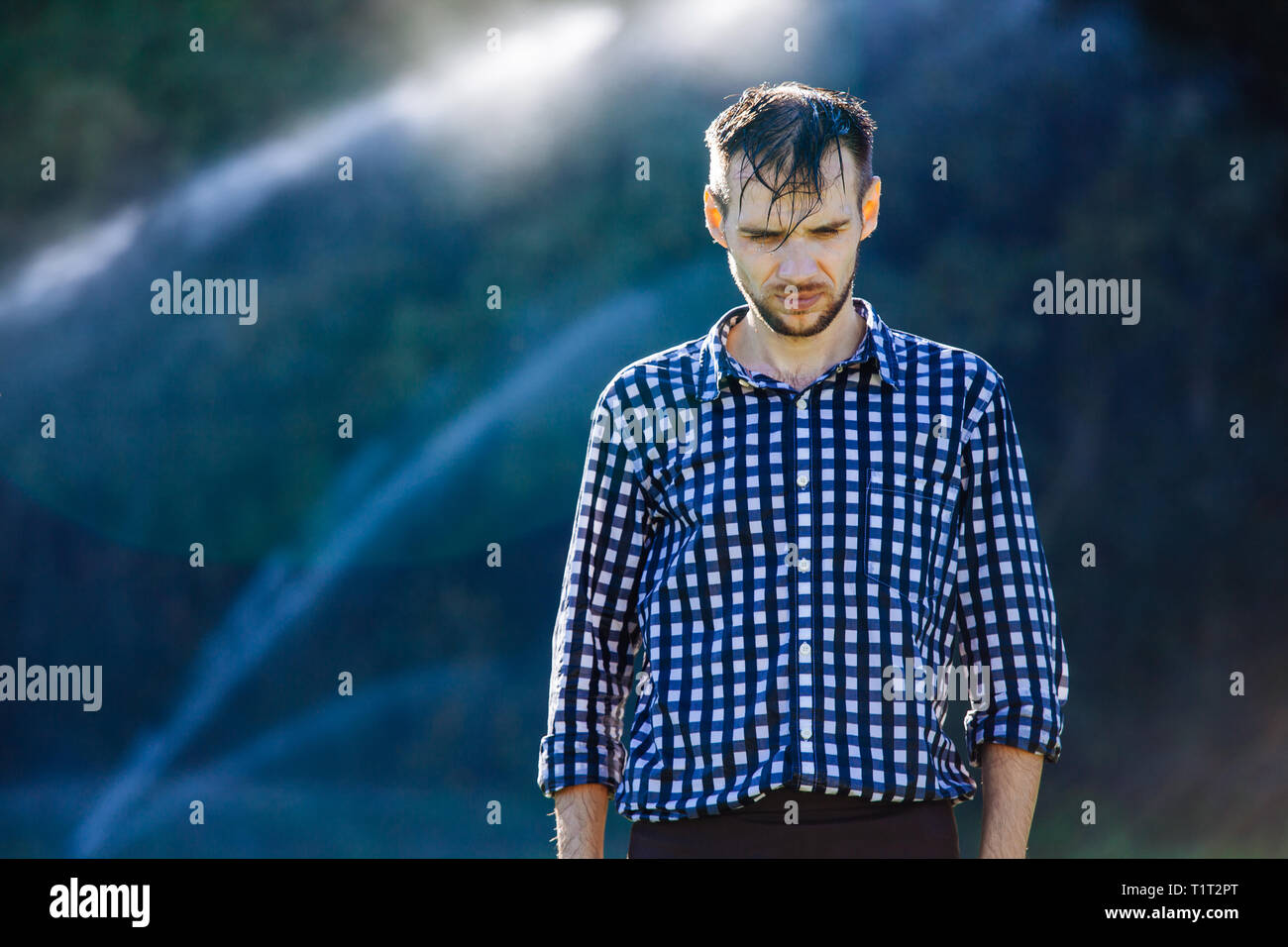 Portrait of a strong, drenched man in the rain. Young man getting wet ...