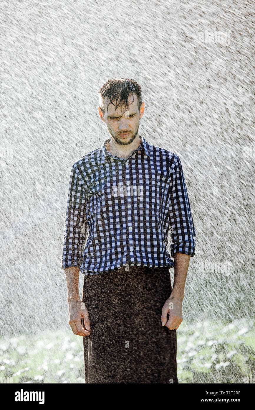 Portrait of a strong, drenched man in the rain. Young man getting wet ...