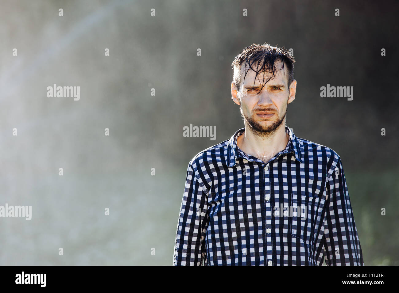 Portrait of a strong, drenched man in the rain. Young man getting wet ...