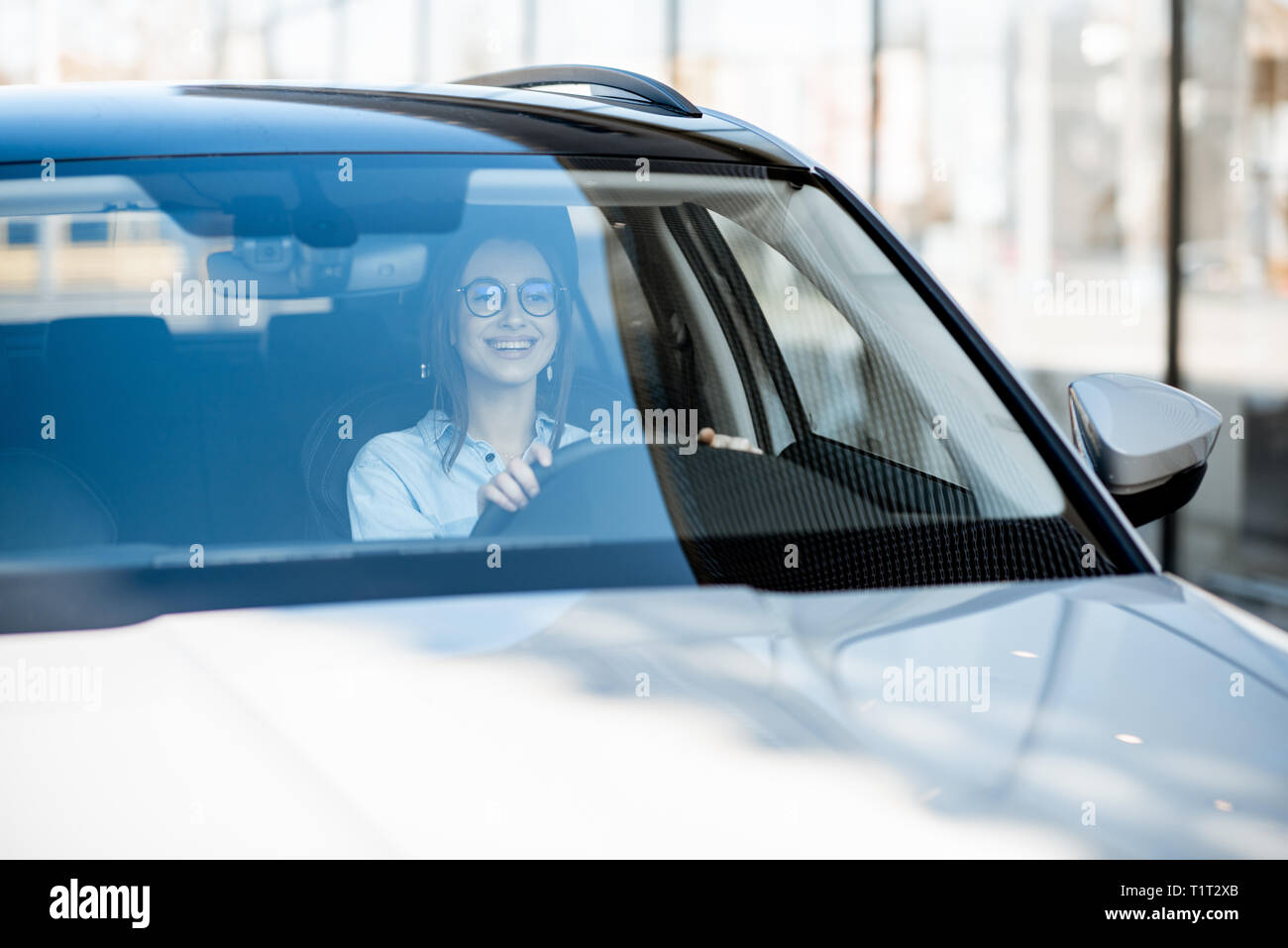 Young woman driver through windscreen hi-res stock photography and ...