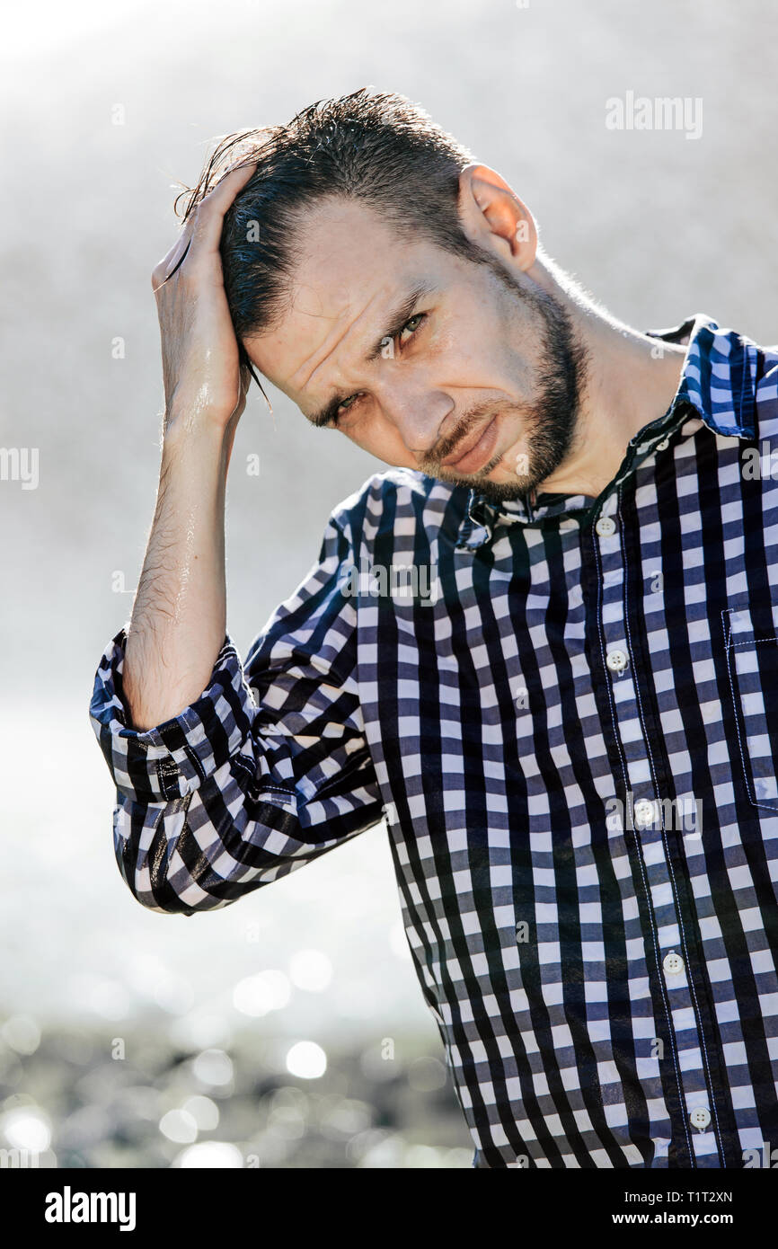 Portrait of a strong, drenched man in the rain. Young man getting wet ...