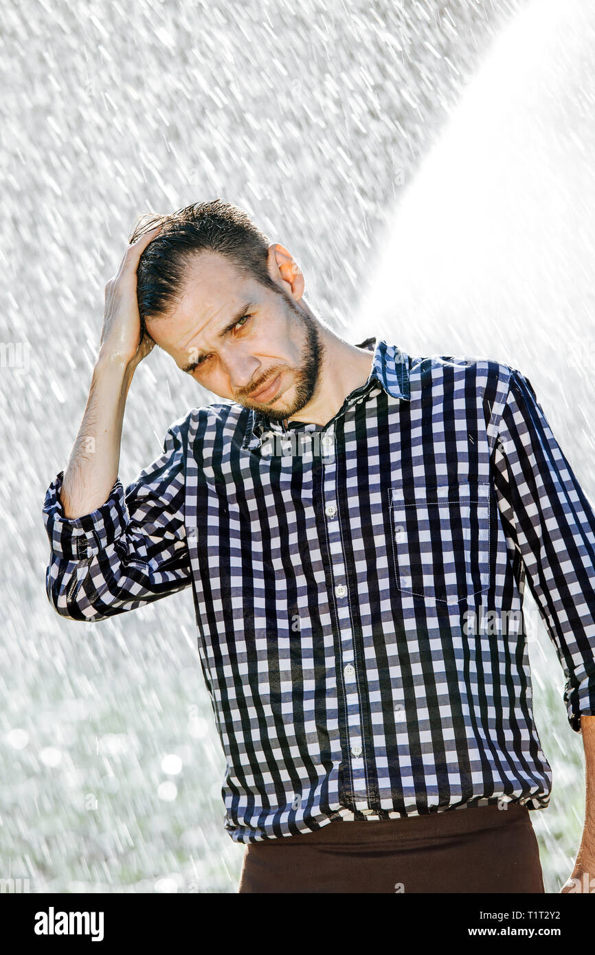 Portrait of a strong, drenched man in the rain. Young man getting wet ...