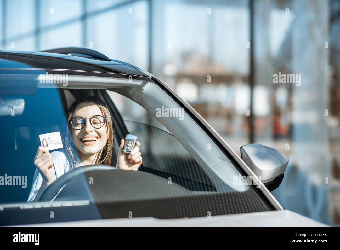 Portrait of a young woman with excited emotions holding keys and ...
