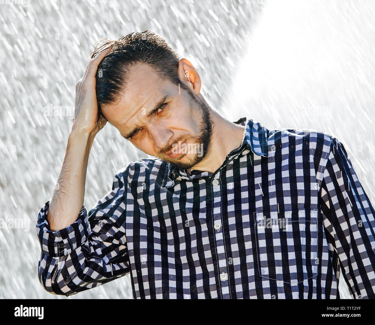 Portrait of a strong, drenched man in the rain. Young man getting wet ...