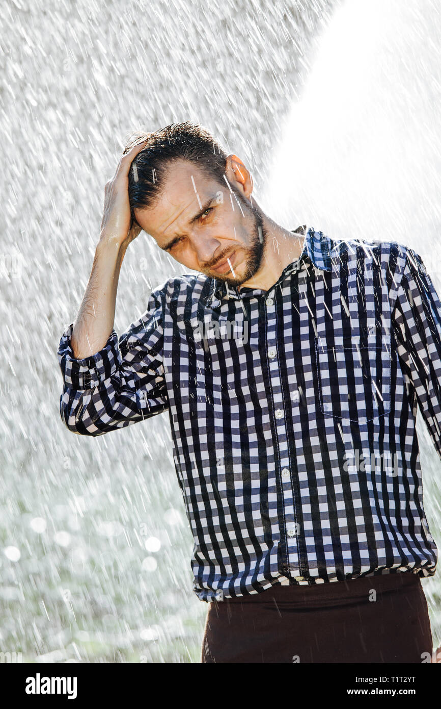 Portrait of a strong, drenched man in the rain. Young man getting wet ...