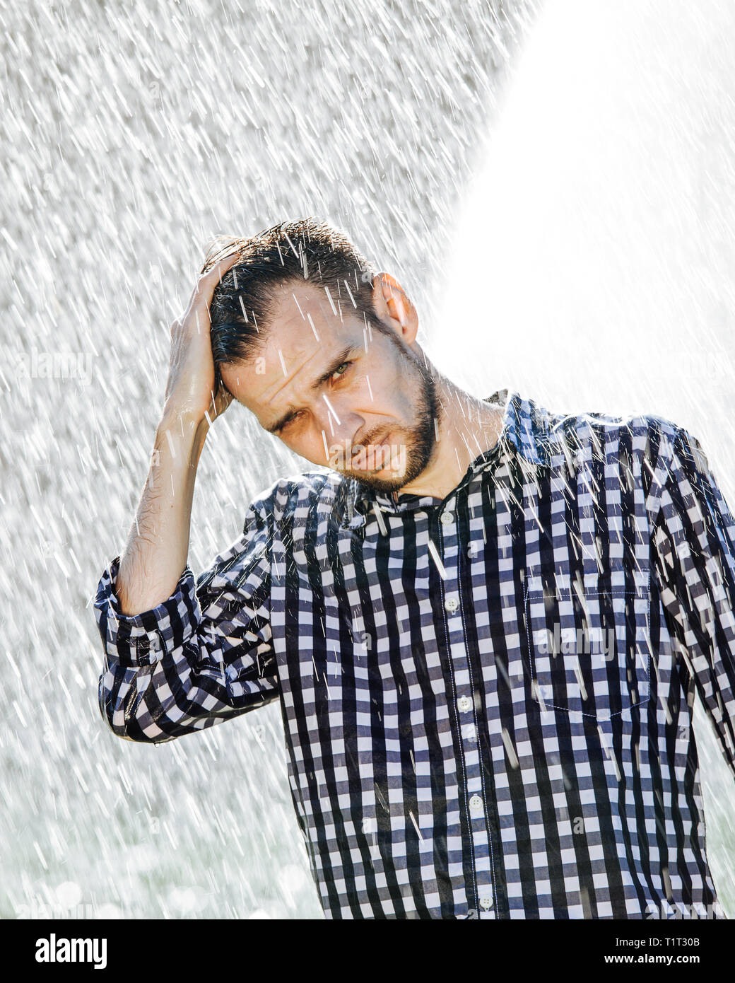 Portrait of a strong, drenched man in the rain. Young man getting wet ...