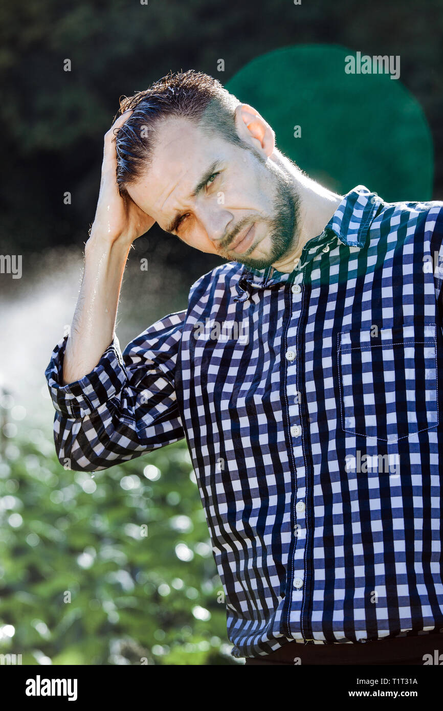 Portrait of a strong, drenched man in the rain. Young man getting wet ...