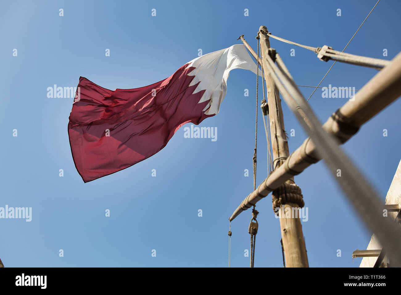 Flag of Qatar waving in the wind with the blue sky background Stock ...