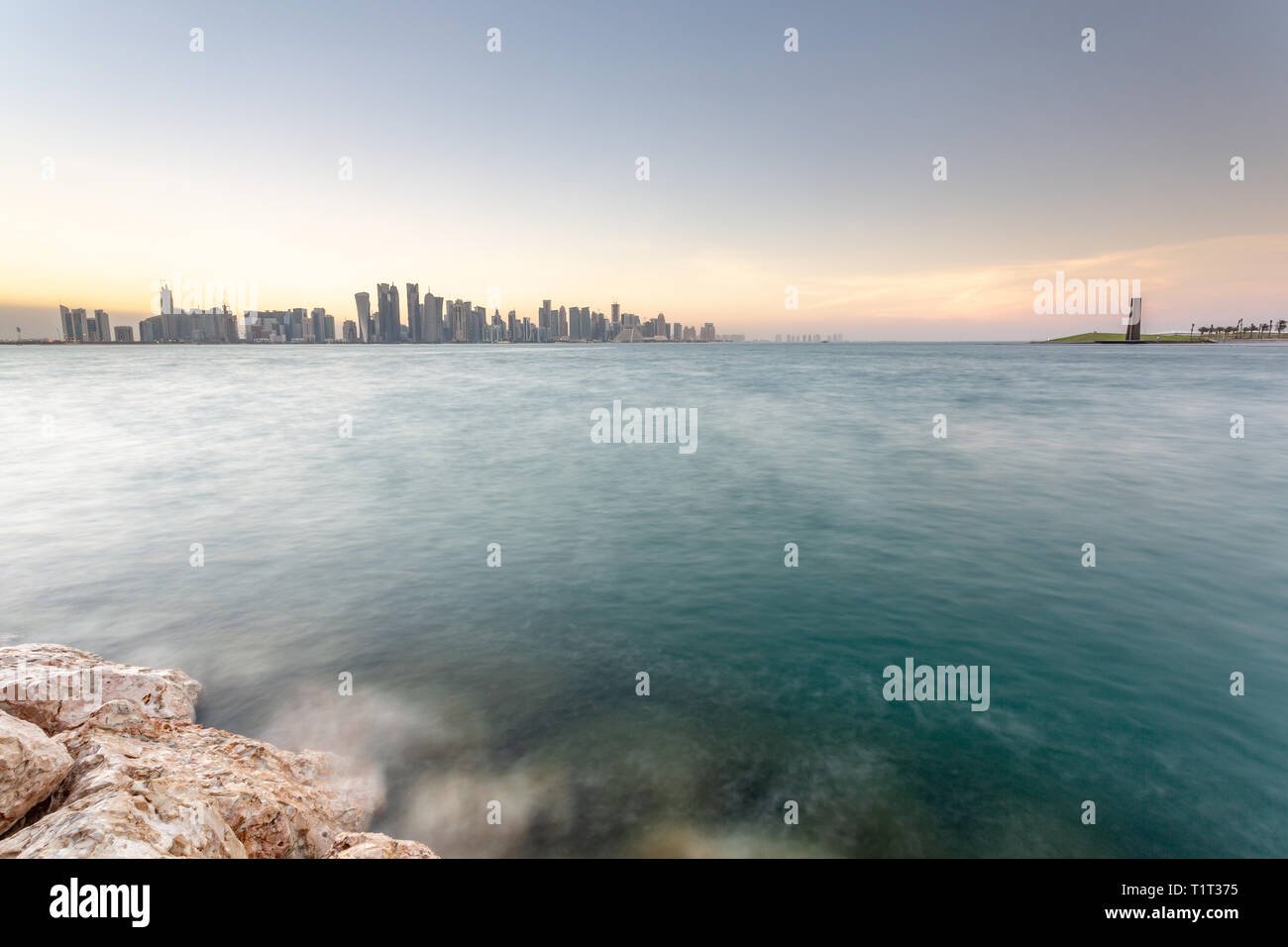 Doha skyline with calm wave of sea water Stock Photo - Alamy