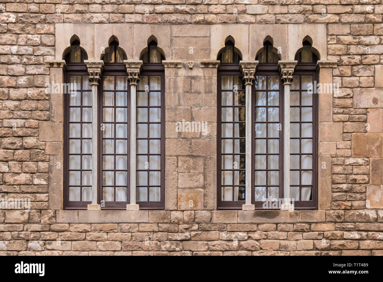 Two windows in a row on the facade of the urban historic building front ...
