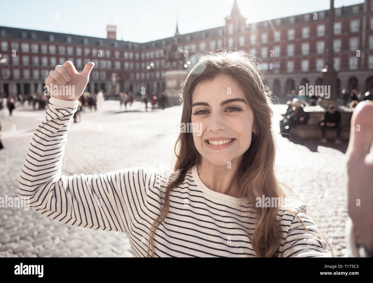Beautiful young student tourist woman happy and excited in Plaza Mayor ...