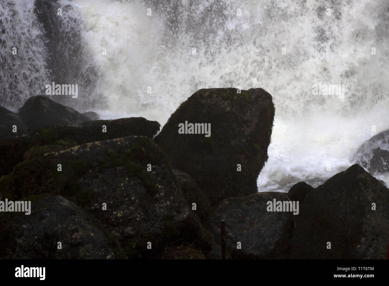 Water from a waterfall crashes down onto the rocks below Stock Photo ...