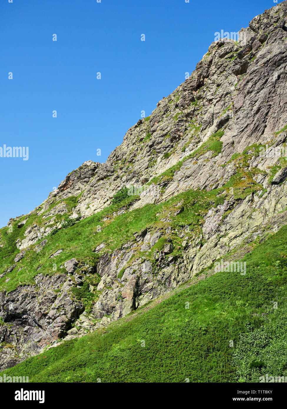 The rock on a high mountain slope, Blue sky in the mountains on a ...