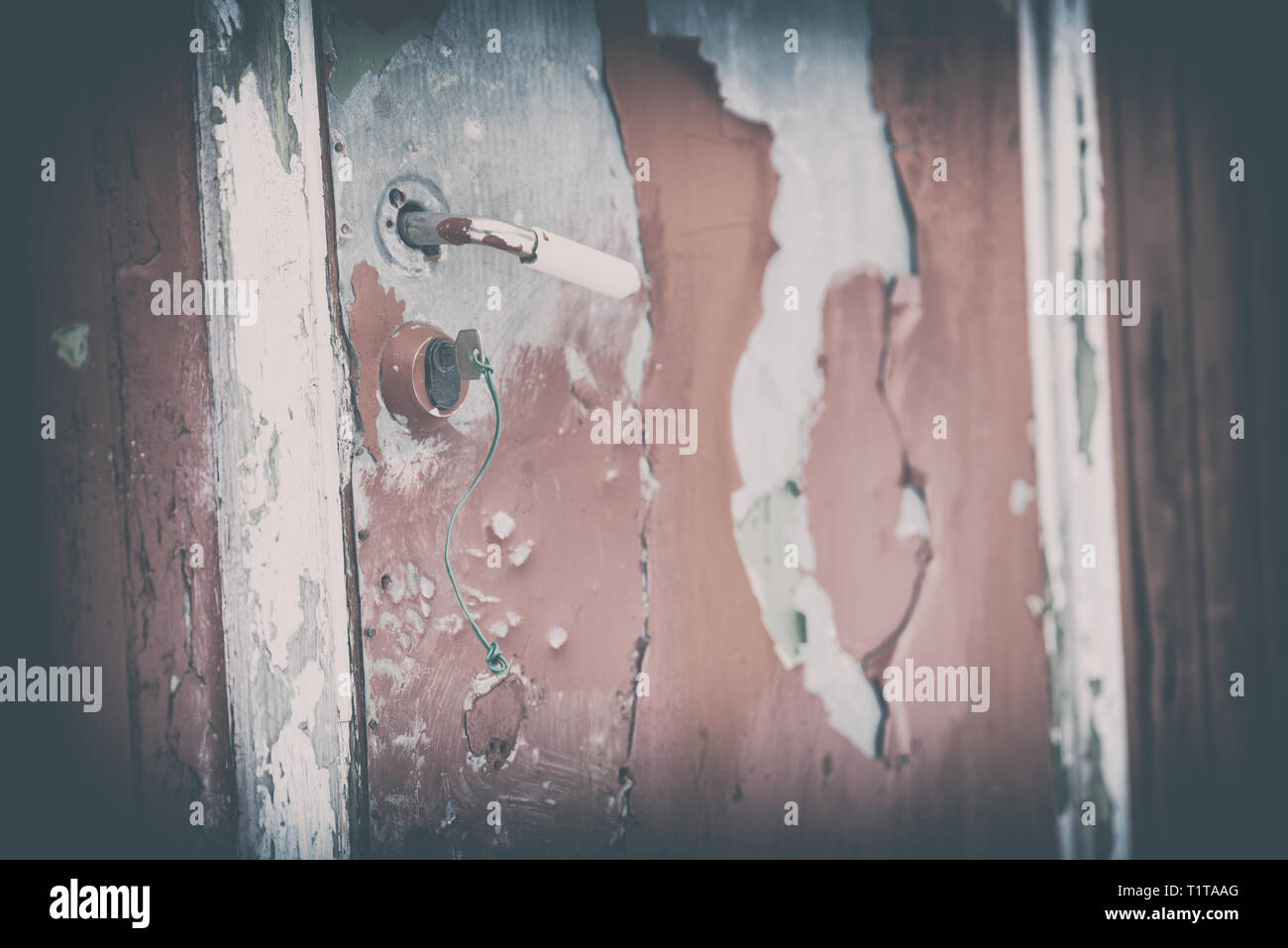 Old worn door with key in lock Stock Photo - Alamy