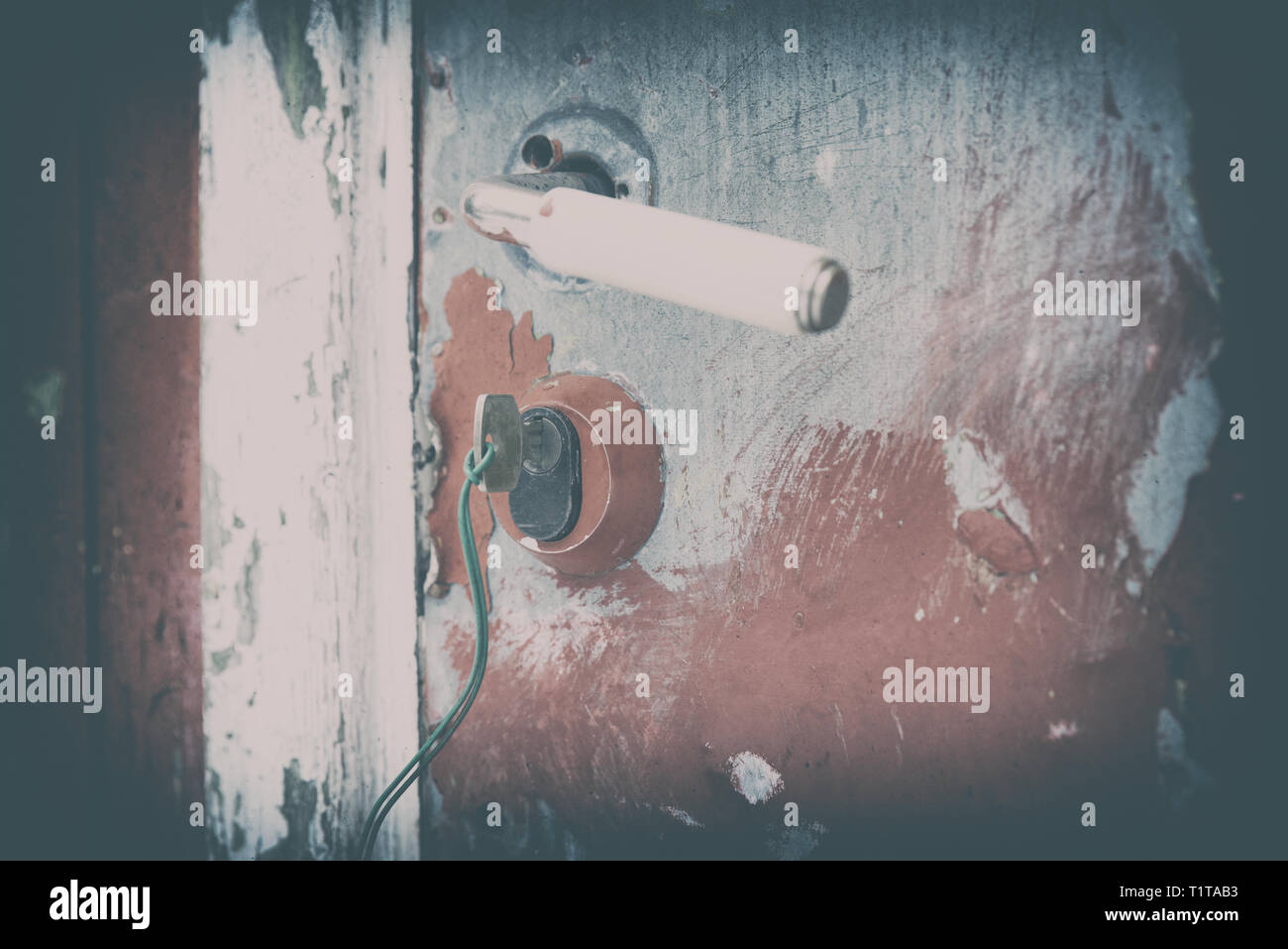 Old worn door with key in lock Stock Photo - Alamy