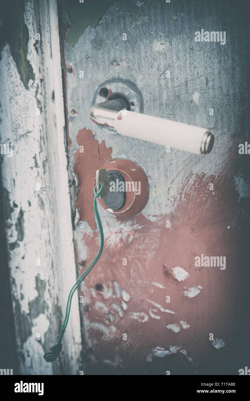 Old worn door with key in lock Stock Photo - Alamy
