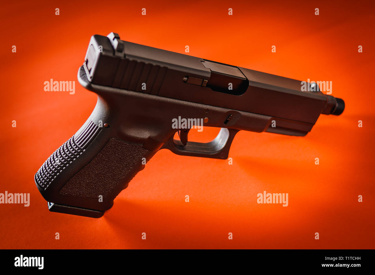 one black handgun on intense red background Stock Photo - Alamy