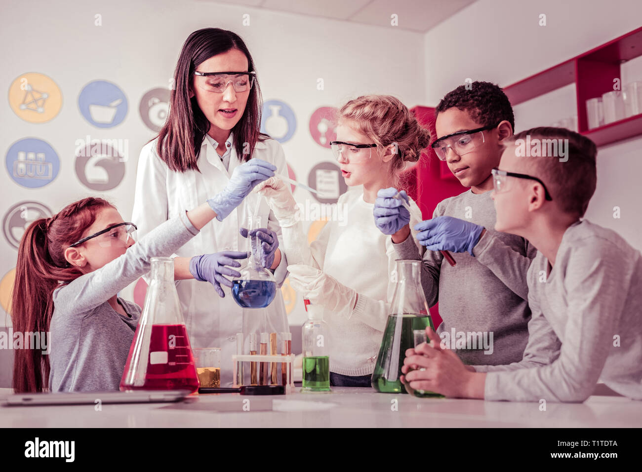 Young scientists helping their teacher with reagents Stock Photo - Alamy